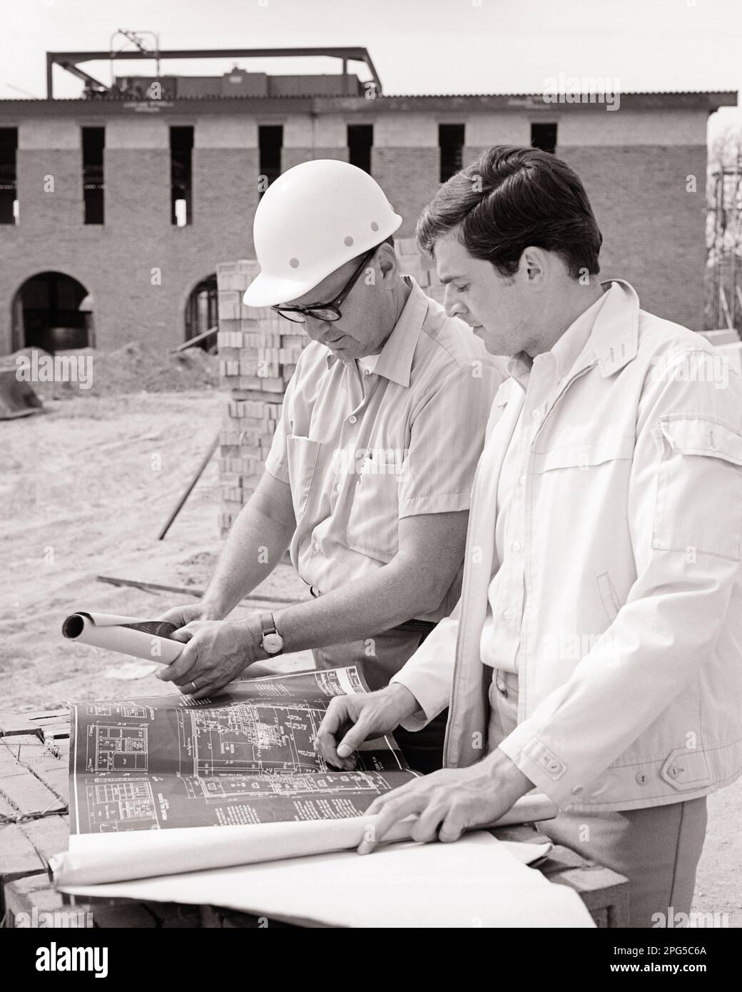 1960s TWO MEN ON CONSTRUCTION SITE ONE WEARING HARD HAT GENERAL ...