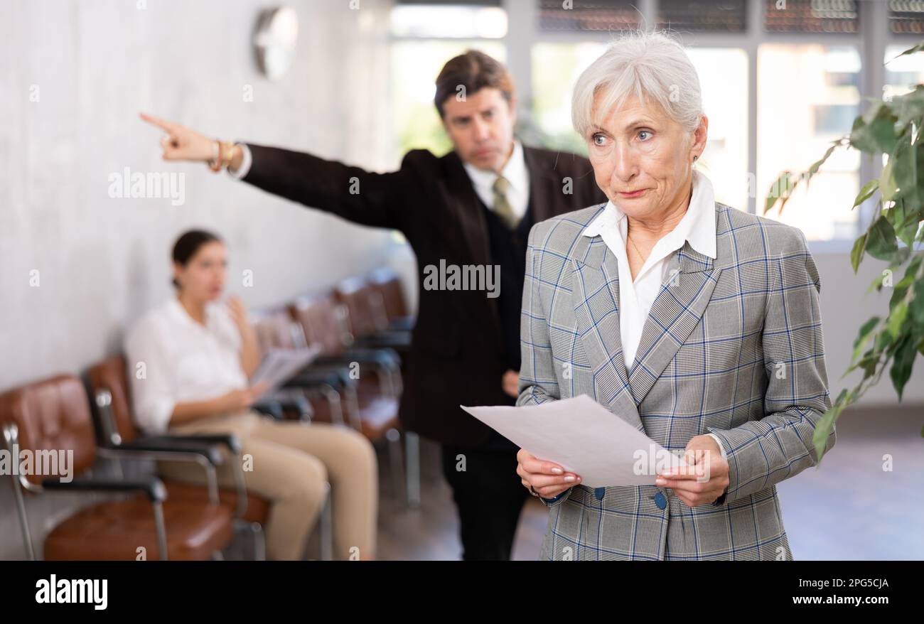 Upset senior businesswoman with displeased boss pointing at door Stock ...