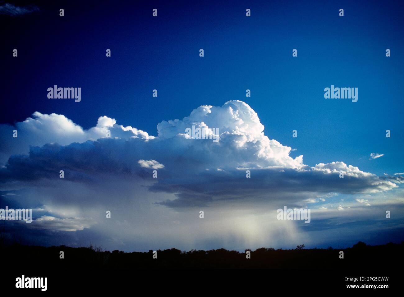 1990s RAIN AND SUNLIGHT FROM CUMULUS CLOUDS WITH BLUE SKIES ABOVE ...