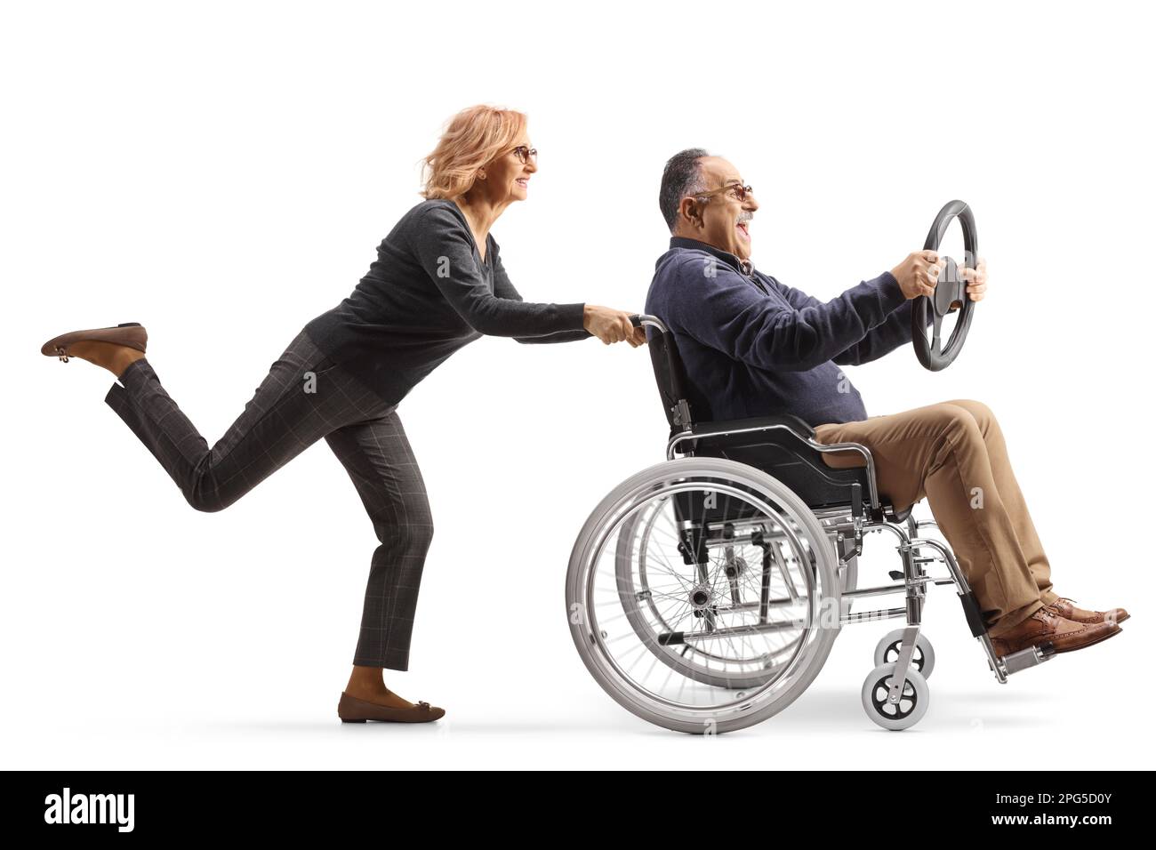 Woman pushing a man in a wheelchair sitting and holding a steering ...