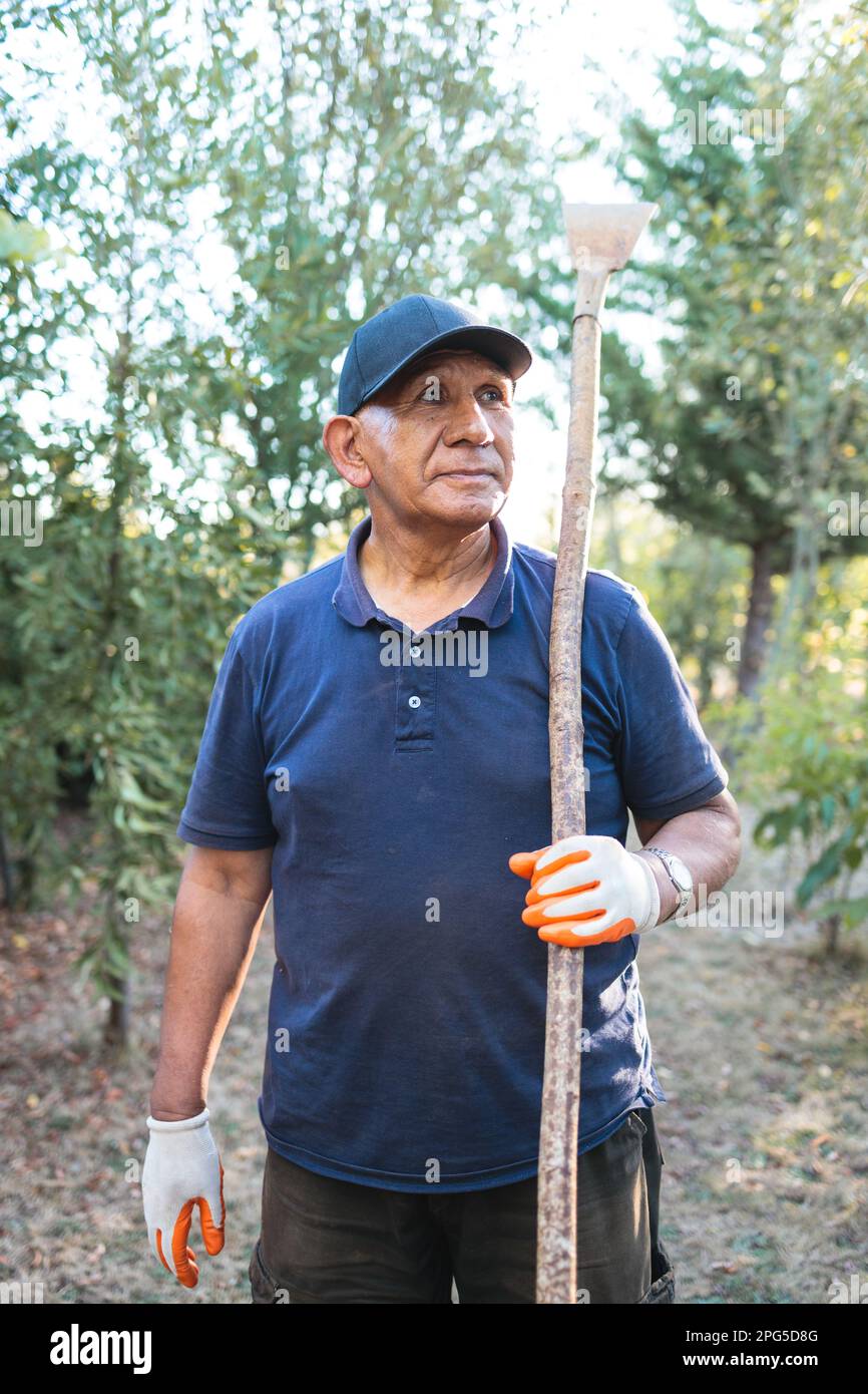 Headshot portrait of a senior indigenous mapuche farmer man holding a ...