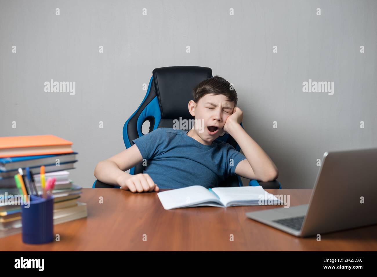 bored school boy learning at home and yawn, prepare home task Stock ...