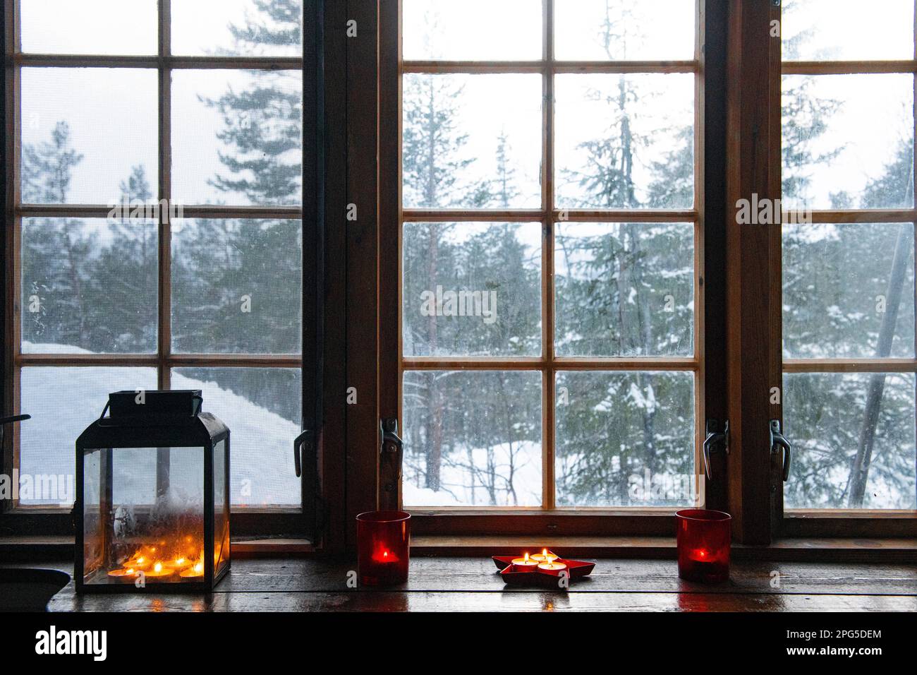 Looking out of a window in a remote cabin in a snowy forest in Norway ...