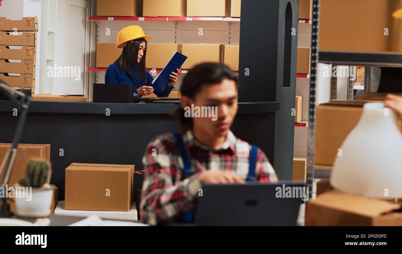 Two employees checking goods for distribution, putting depot products ...