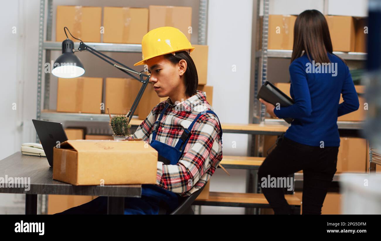 Young man analyzing products in boxes before shipment, checking ...