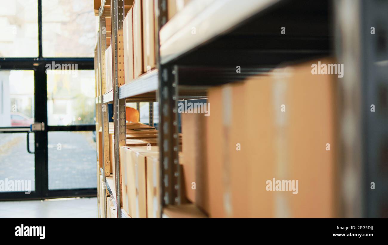 Cardboard boxes and packages with merchandise in depot, placed on racks ...