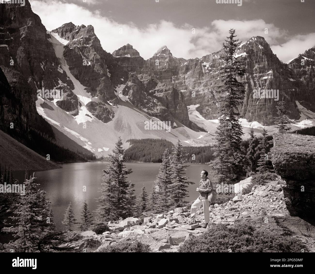 1960s ONE MAN STANDING ON HILL BY MORAINE LAKE IN CANADIAN ROCKIES ...