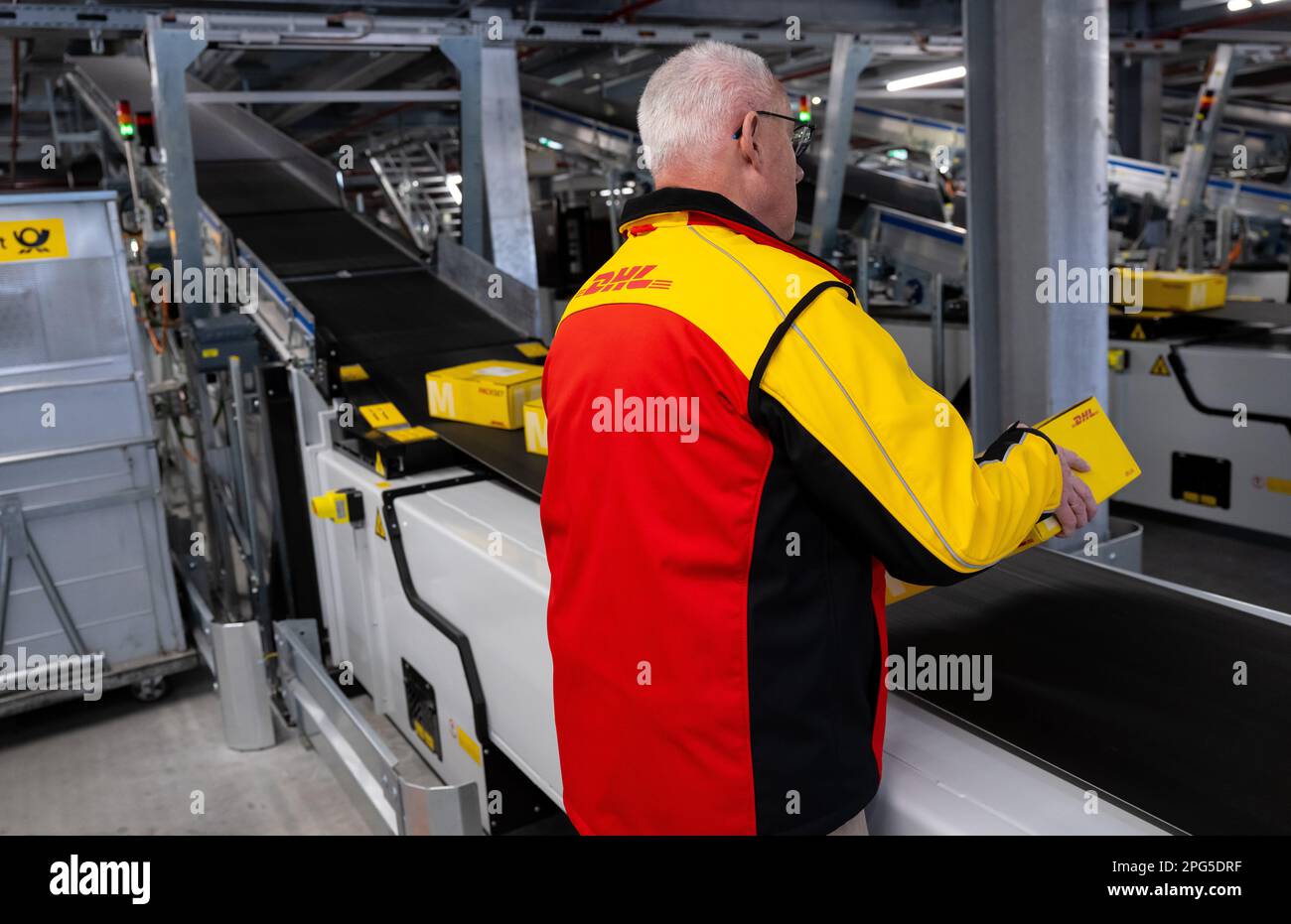 Aschheim, Germany. 20th Mar, 2023. An employee places parcels on a ...