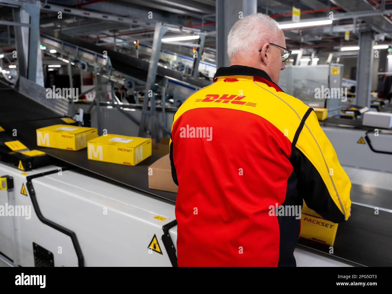 Aschheim, Germany. 20th Mar, 2023. An employee places parcels on a ...