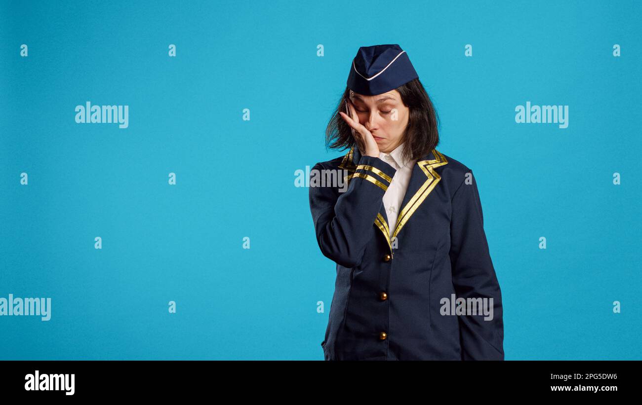 Air hostess feeling tired and yawning in studio, being drained and worn ...