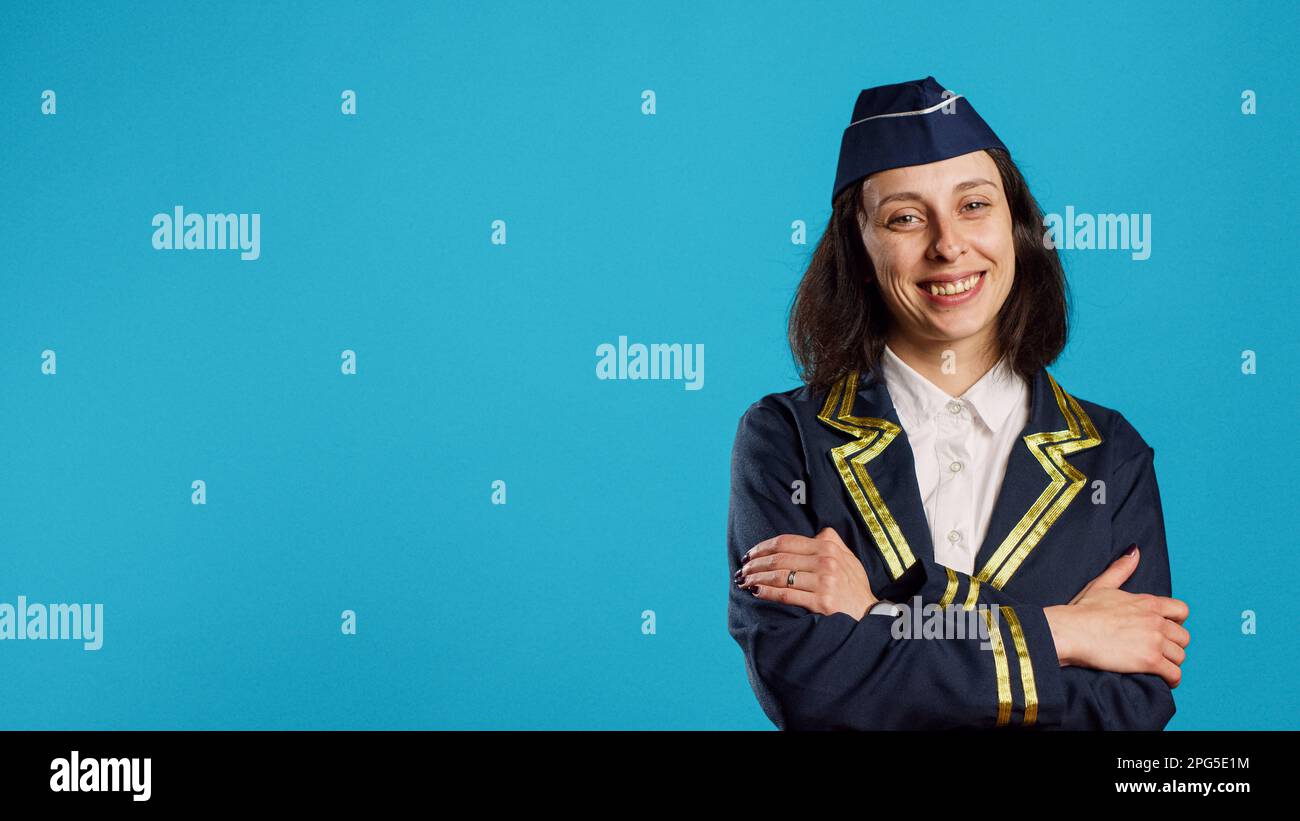 Confident young stewardess posing in flying uniform, feeling happy ...