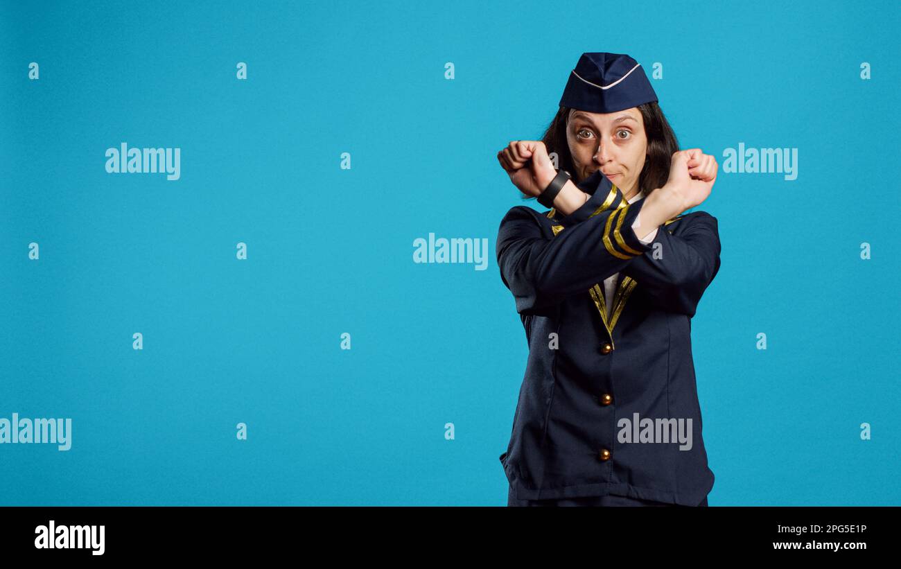 Young air hostess doing x shape gesture and showing disapproval, saying ...