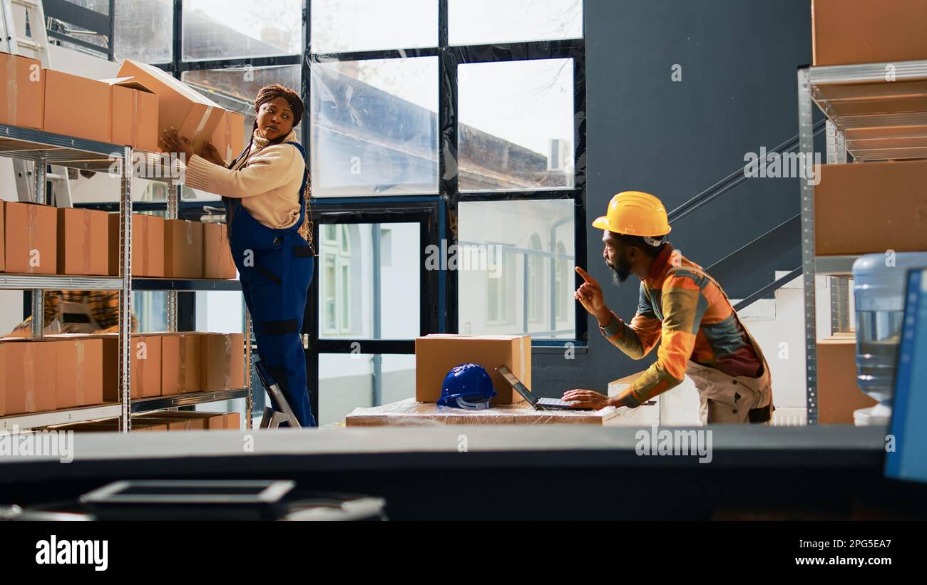 Warehouse employees checking products on shelves, looking at containers ...