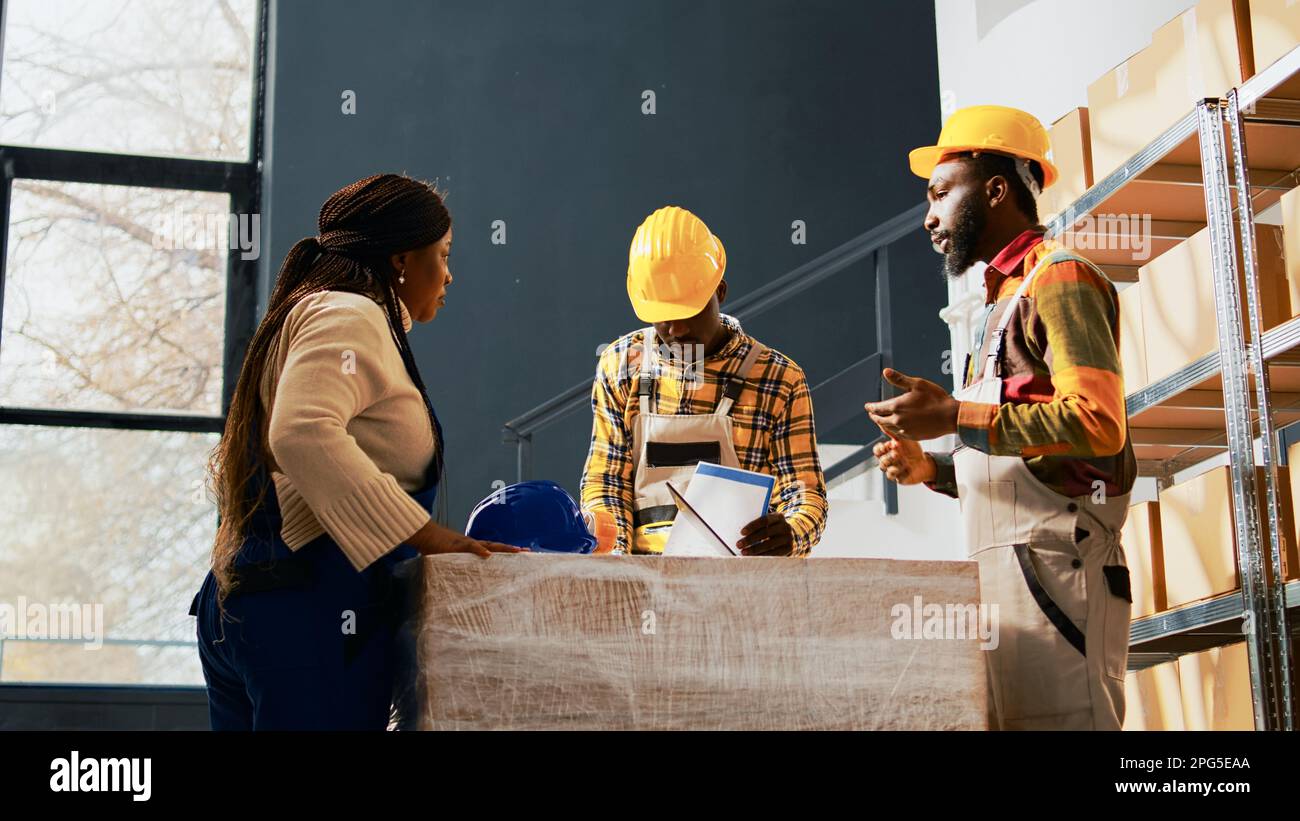 Team of employees putting merchandise in packs, working on distribution ...