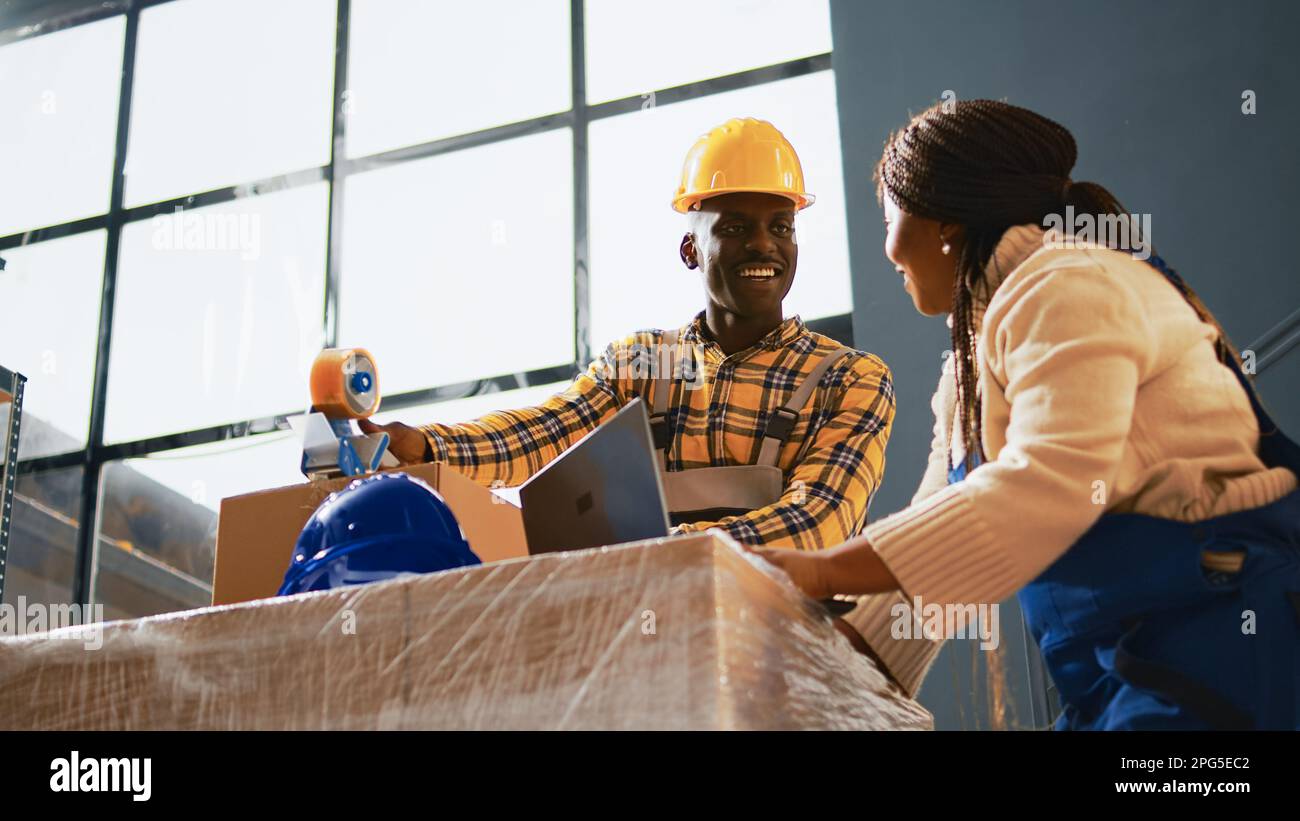 Cheerful people having fun together in warehouse, working on ...