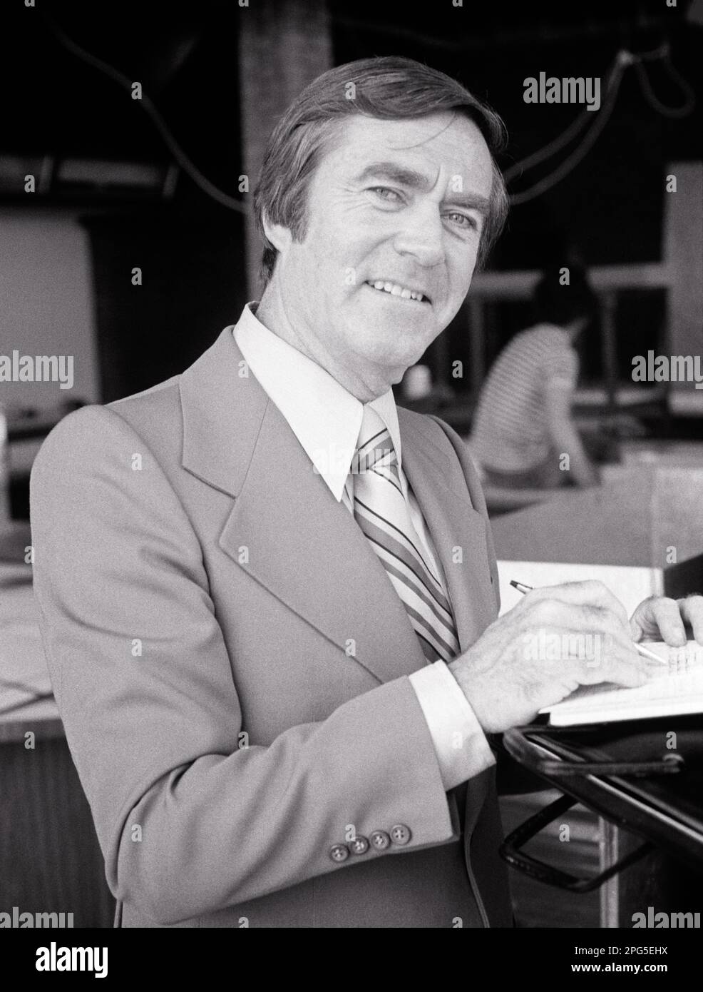 1970s PORTRAIT SMILING BUSINESSMAN WRITING IN NOTEBOOK DIARY WEARING A ...