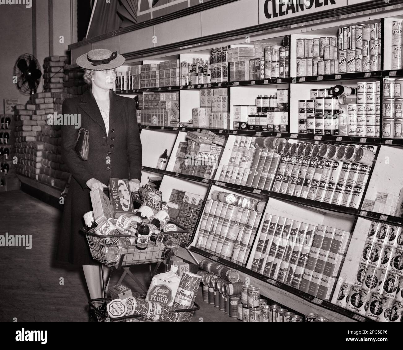 1940s WOMAN PUSHING FULL FOOD SHOPPING CART IN SUPERMARKET WALKING PAST ...