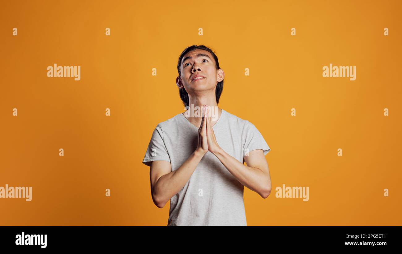 Happy asian man doing prayer hands sign and acting positive, being ...