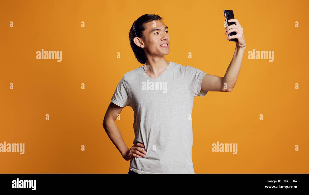 Happy guy taking pictures and acting carefree, smiling and posing for ...