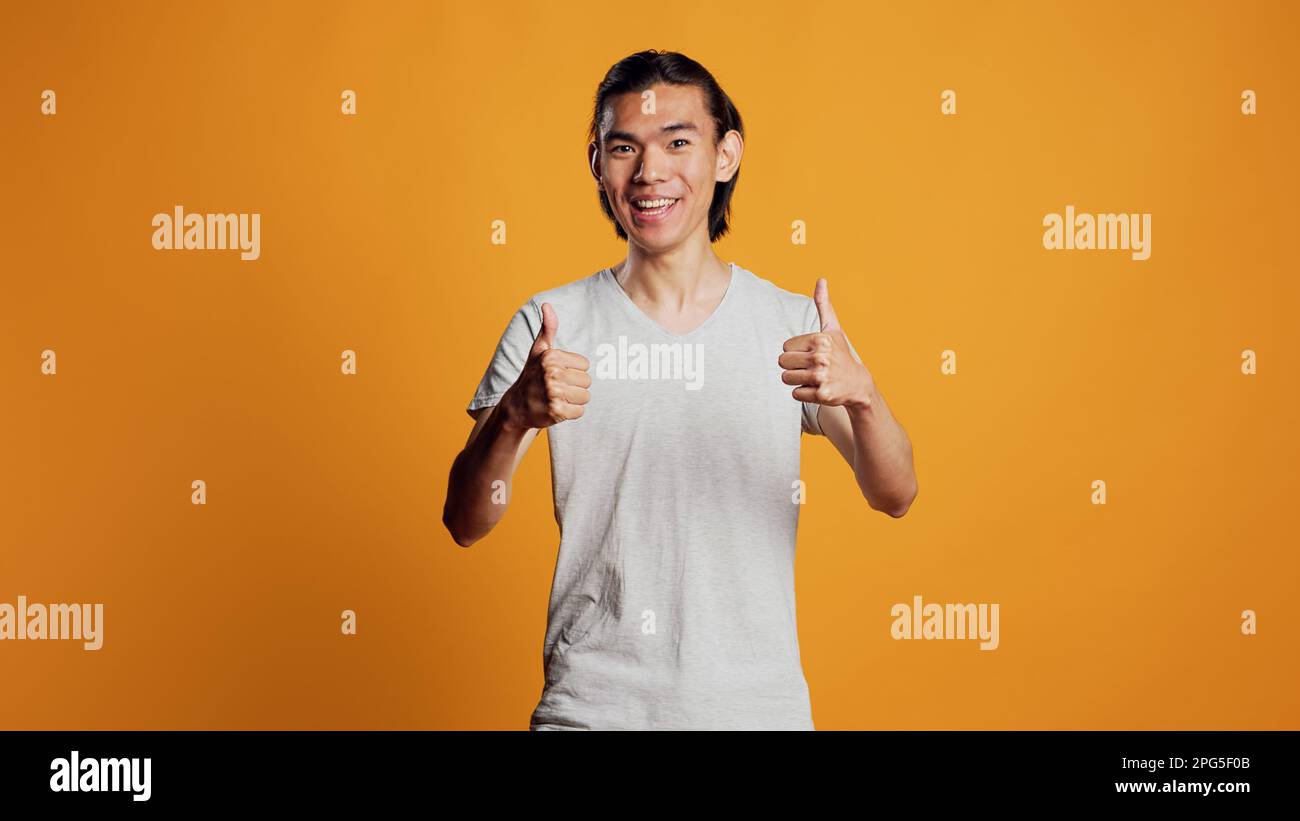 Carefree guy giving thumbs up on camera, expressing agreement and okay ...