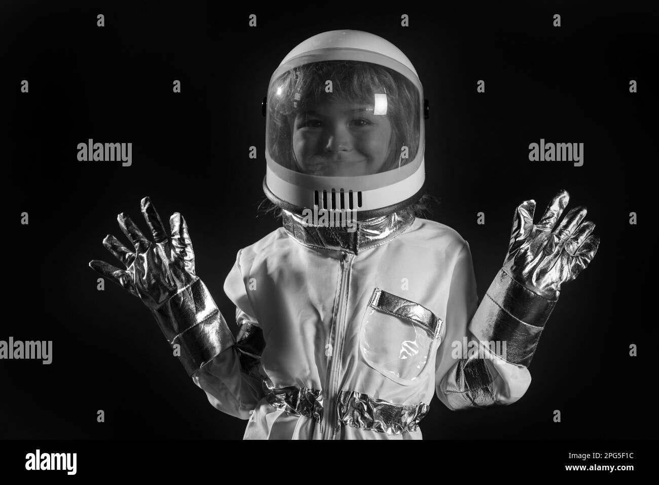 Portrait of wondered little astronaut in helmet and protective space ...