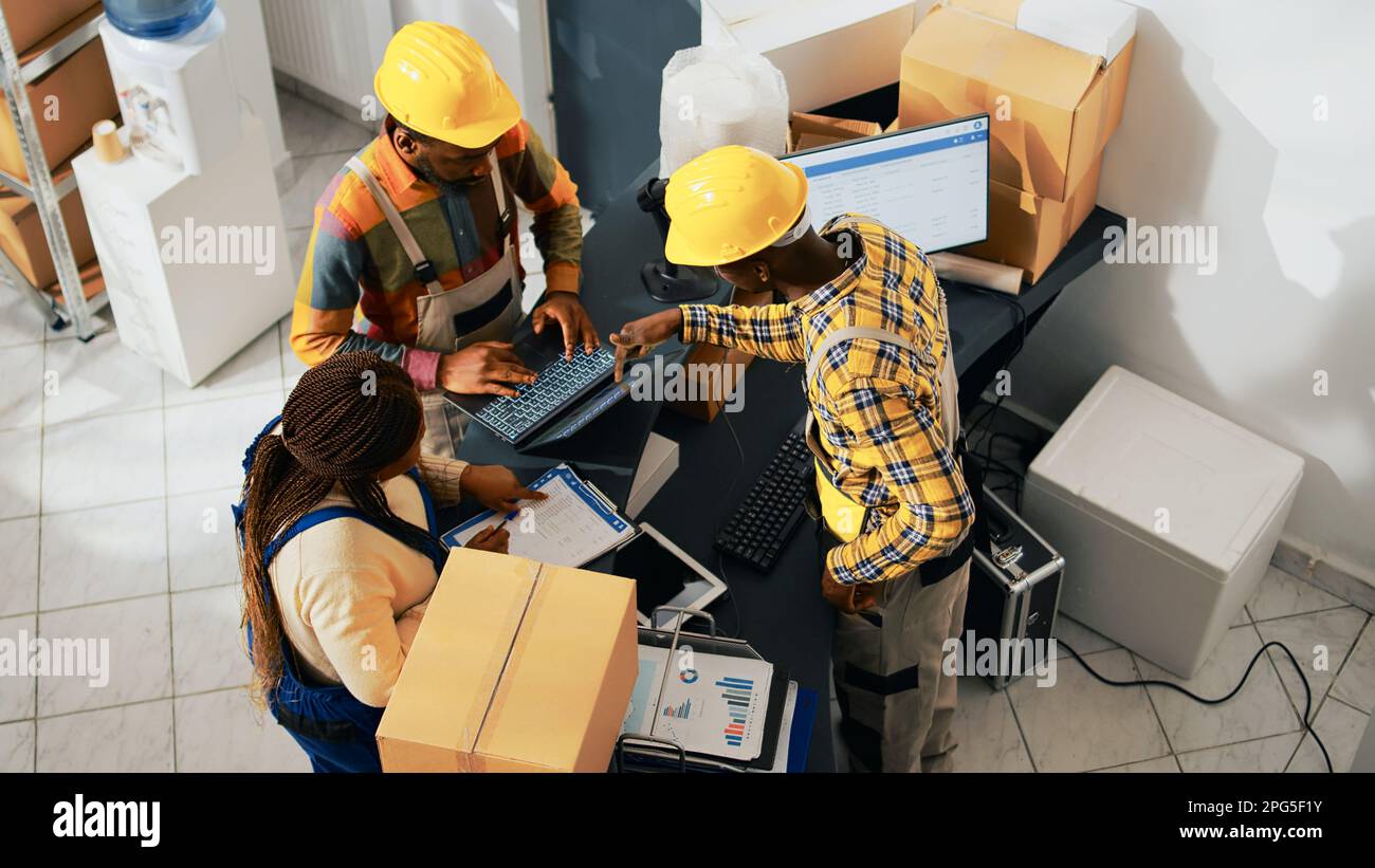 African american colleagues looking at products list, working with ...