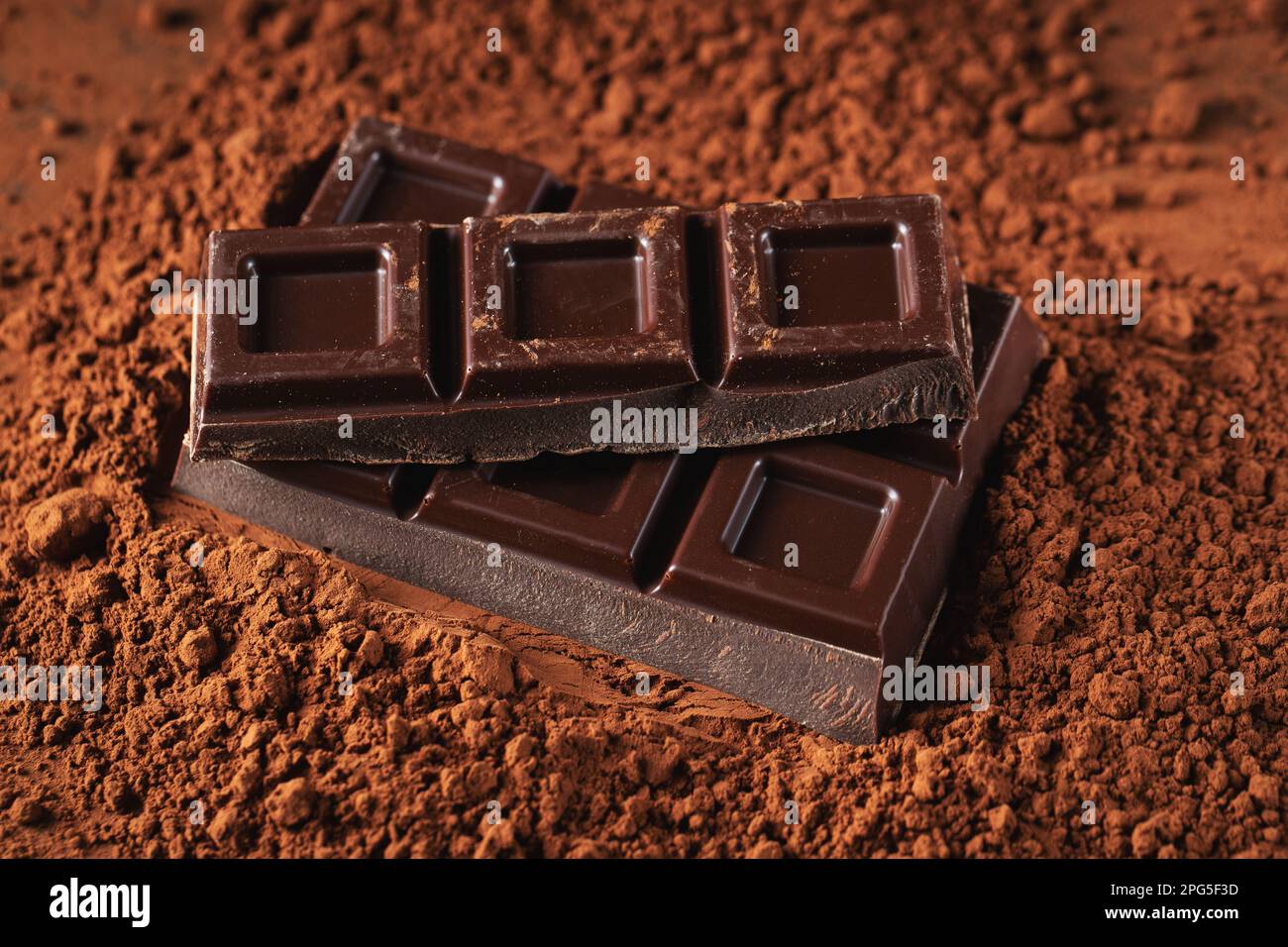 Dark and milk chocolate with nuts on a dark background sprinkled with ...