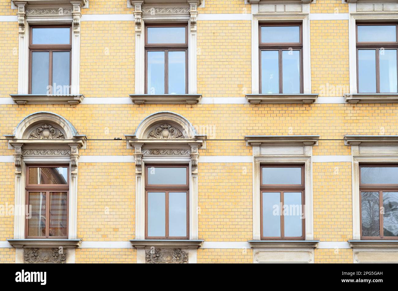 View of brick building with wooden windows Stock Photo - Alamy