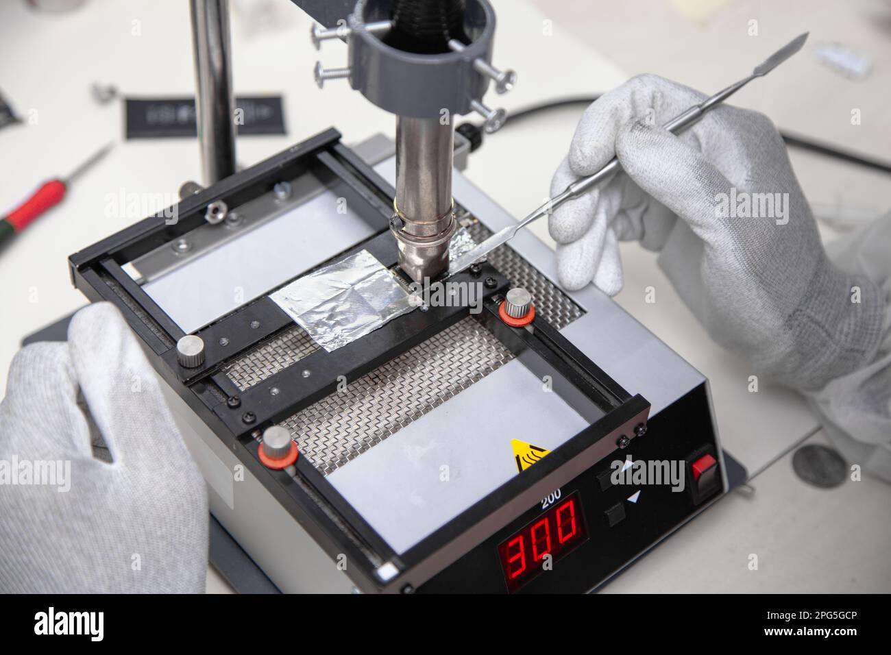 The master solders the microchip at the soldering station. Repair of ...