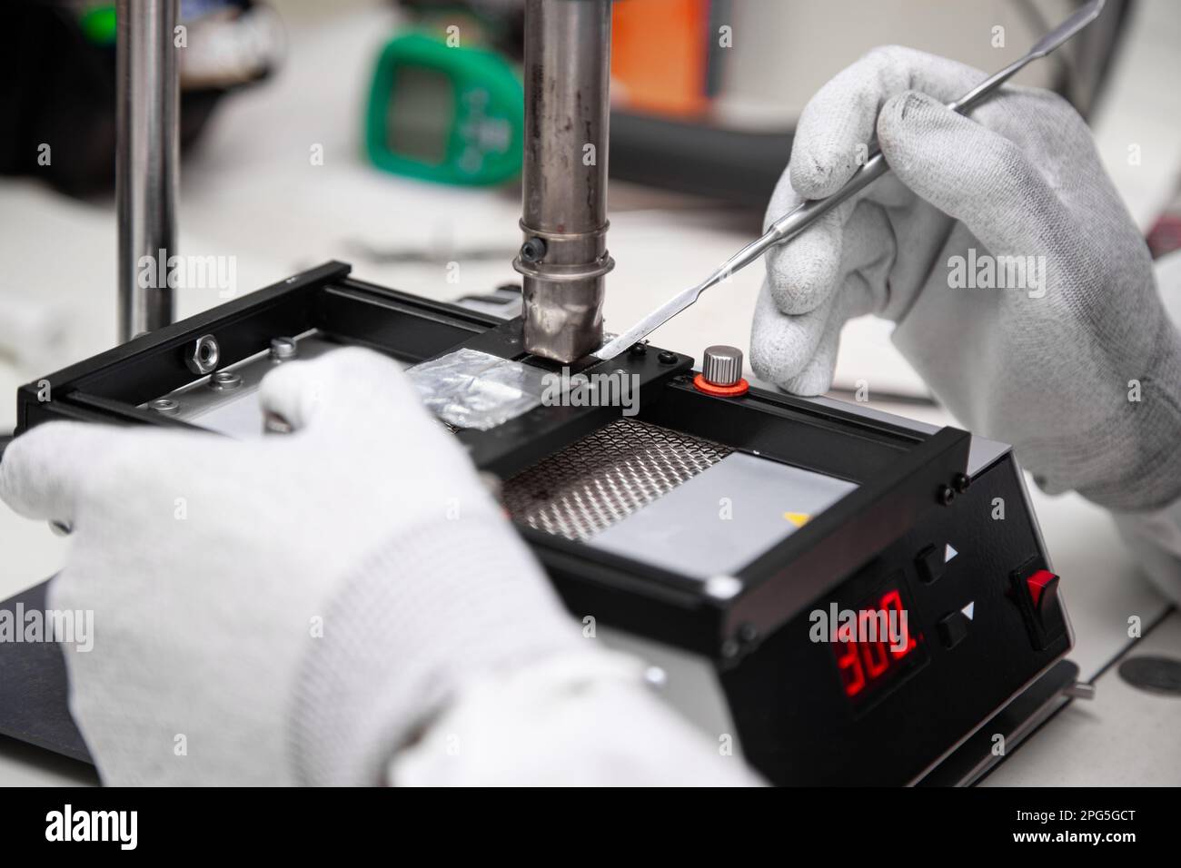 The master solders the microchip at the soldering station. Repair of ...