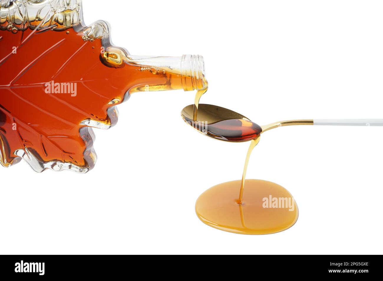 Pouring of tasty maple syrup from bottle into spoon on white background ...