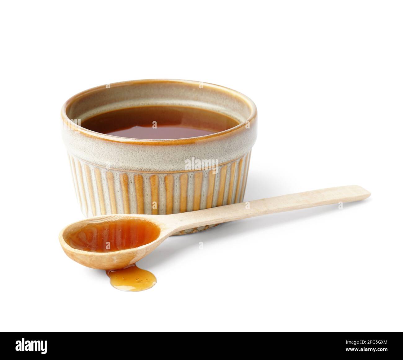 Bowl and spoon of tasty maple syrup on white background Stock Photo - Alamy