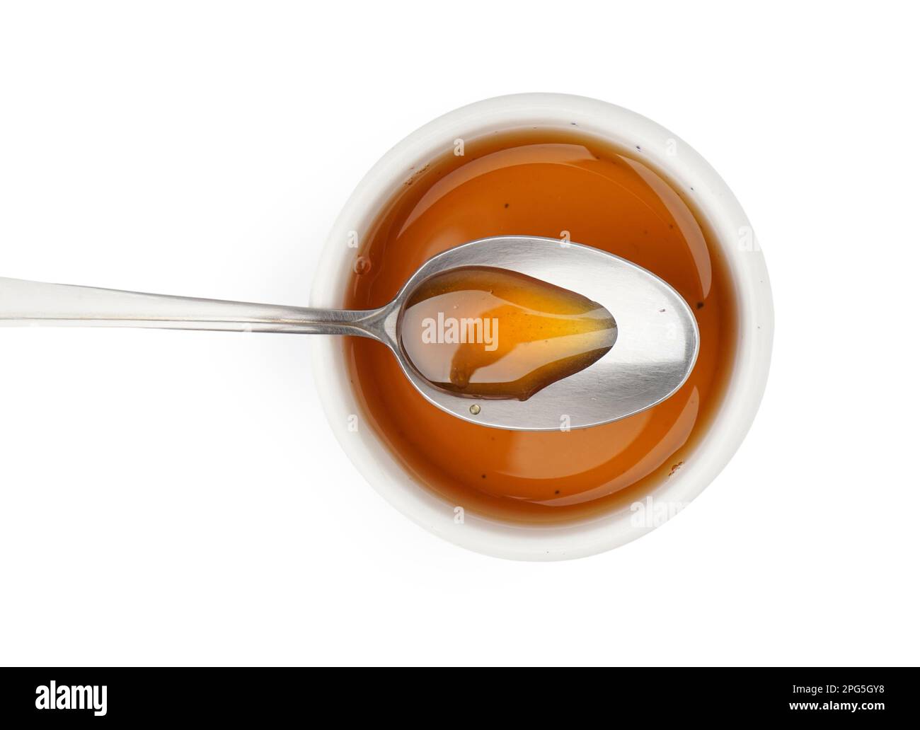 Bowl and spoon of tasty maple syrup on white background Stock Photo - Alamy