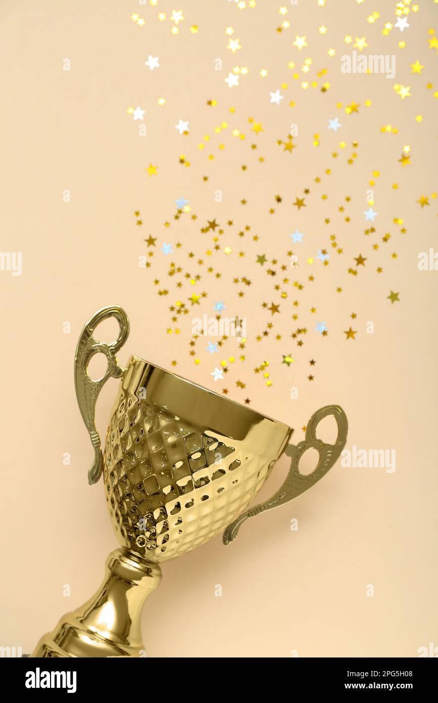 Gold cup with stars on beige background Stock Photo - Alamy