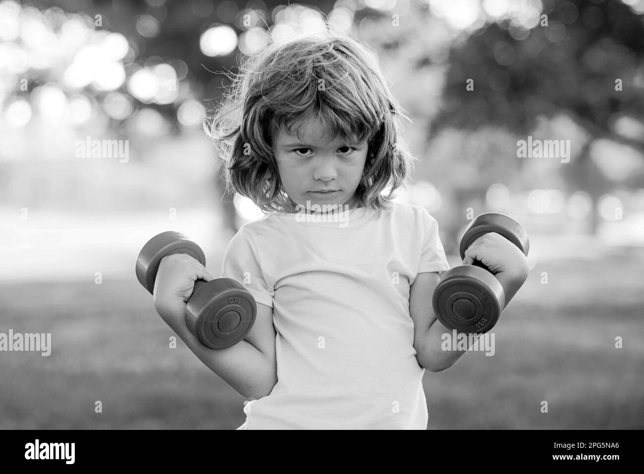 Strong kid exercising dumbbells Black and White Stock Photos & Images ...