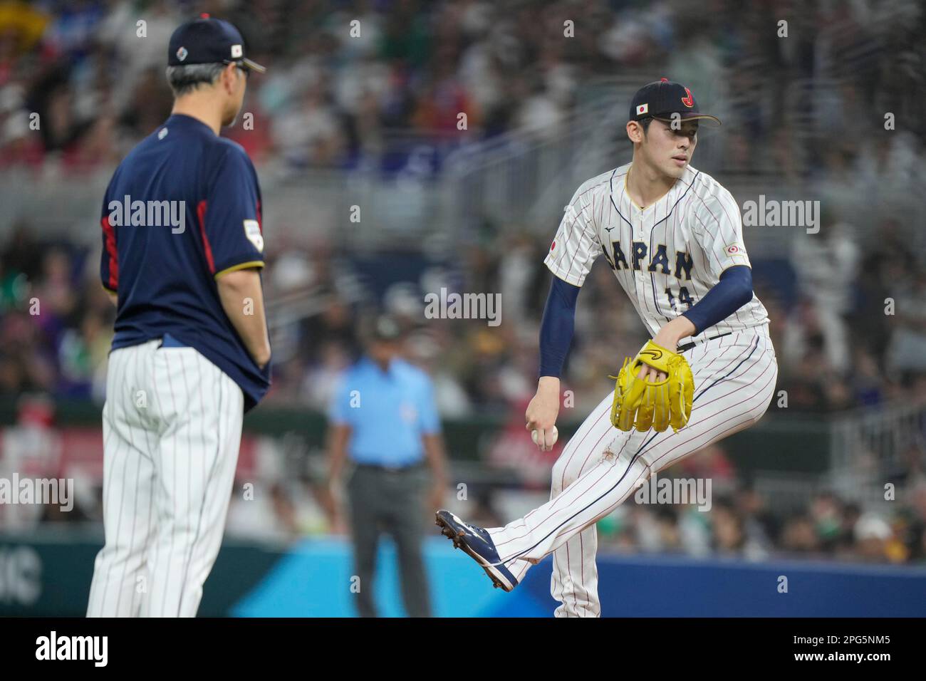 Japan pitching coach Masato Yoshii, left, watches Japan pitcher Roki ...