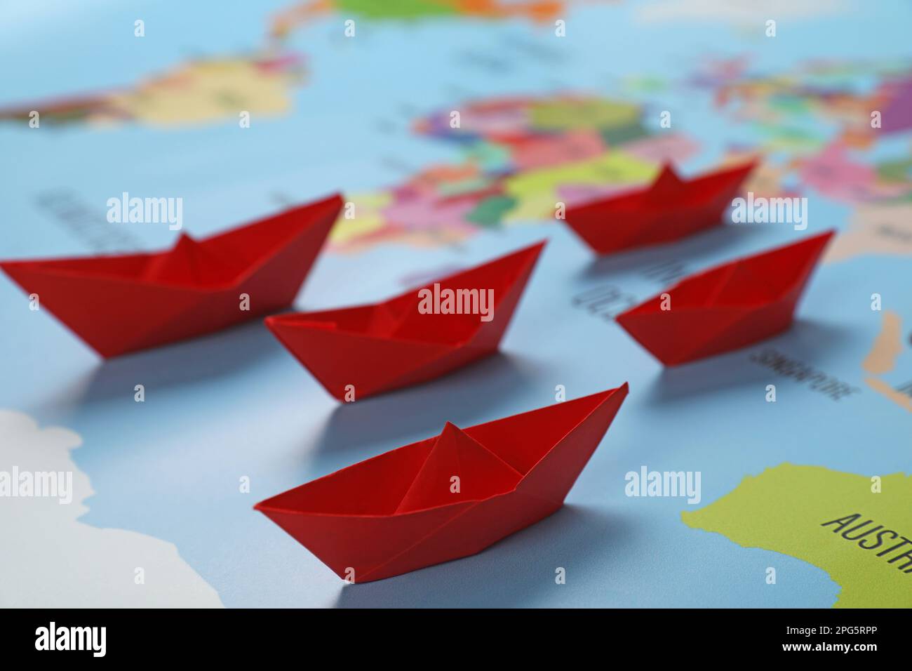 Red paper boats on world map, closeup Stock Photo - Alamy