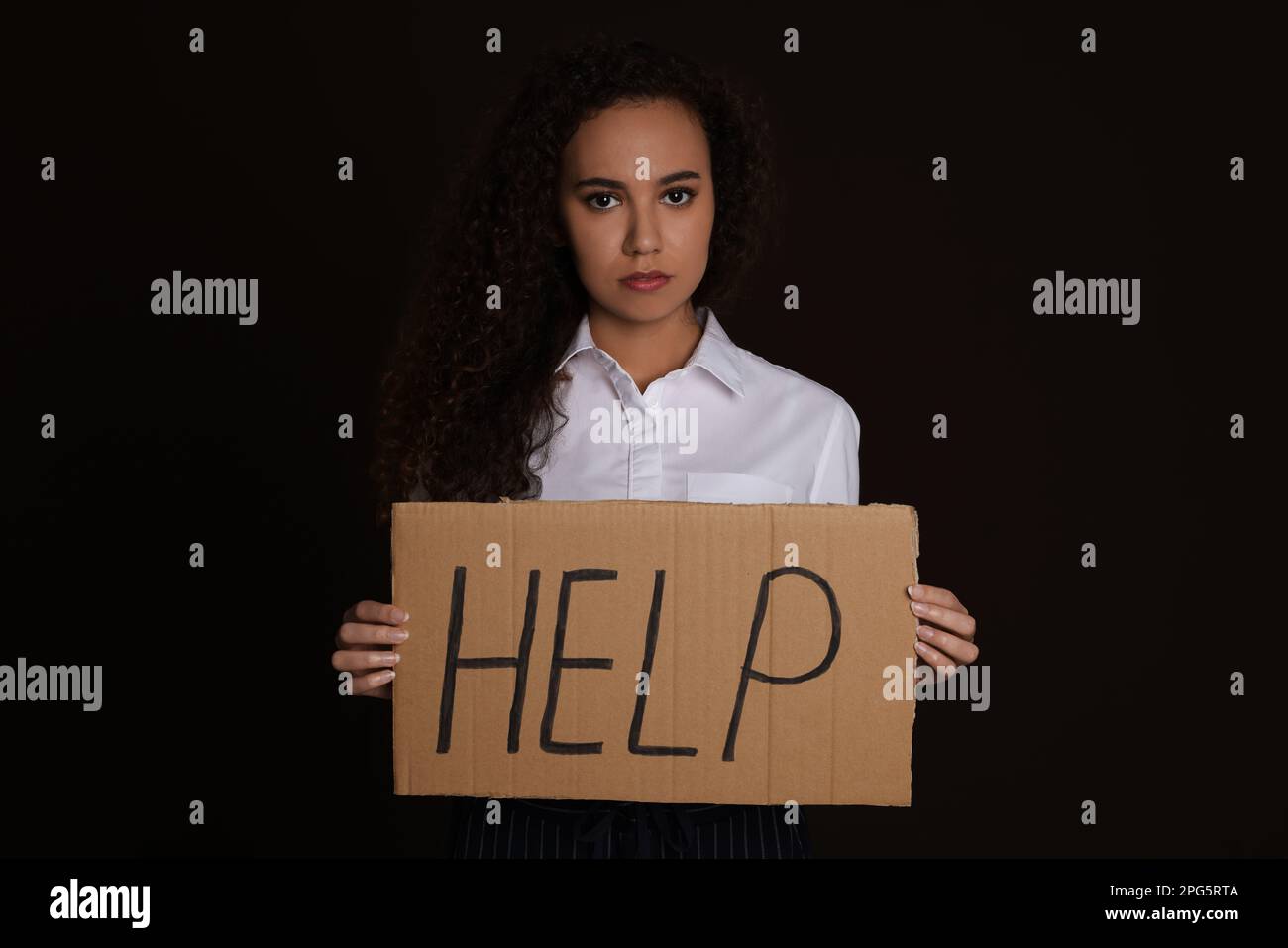 Unhappy African American woman with HELP sign on dark background Stock ...