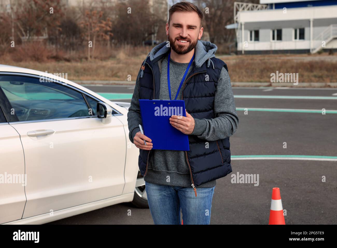Instructor with clipboard near car outdoors. Driving school exam Stock ...