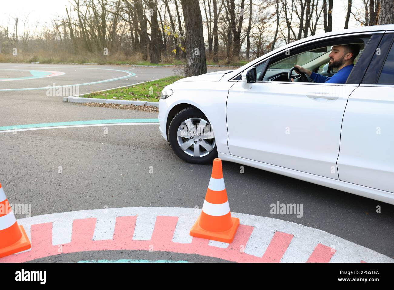 Young man in car on test track with traffic cones. Driving school Stock ...