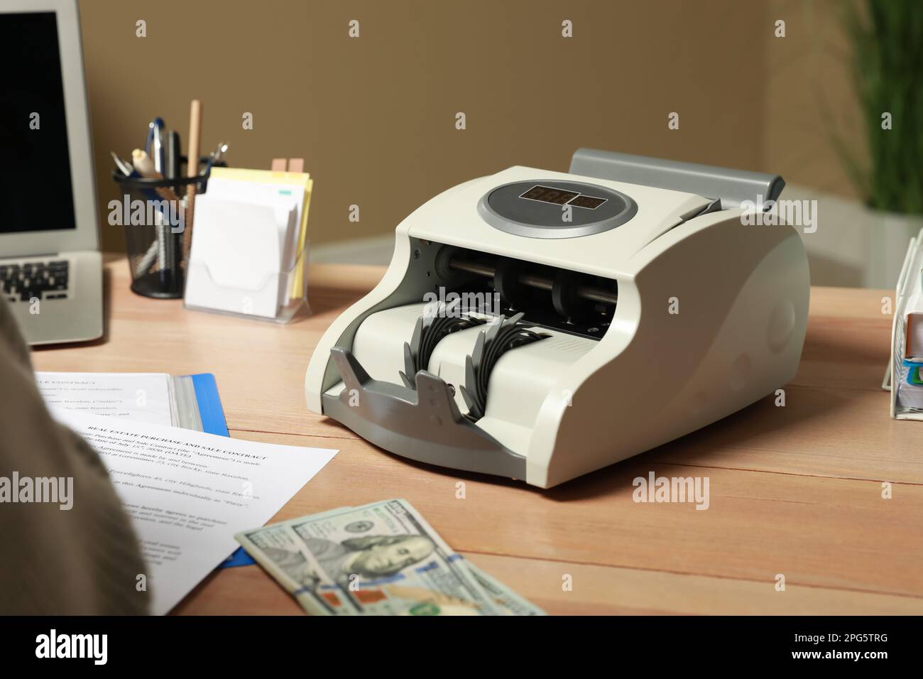 Modern banknote counter on wooden table indoors Stock Photo - Alamy
