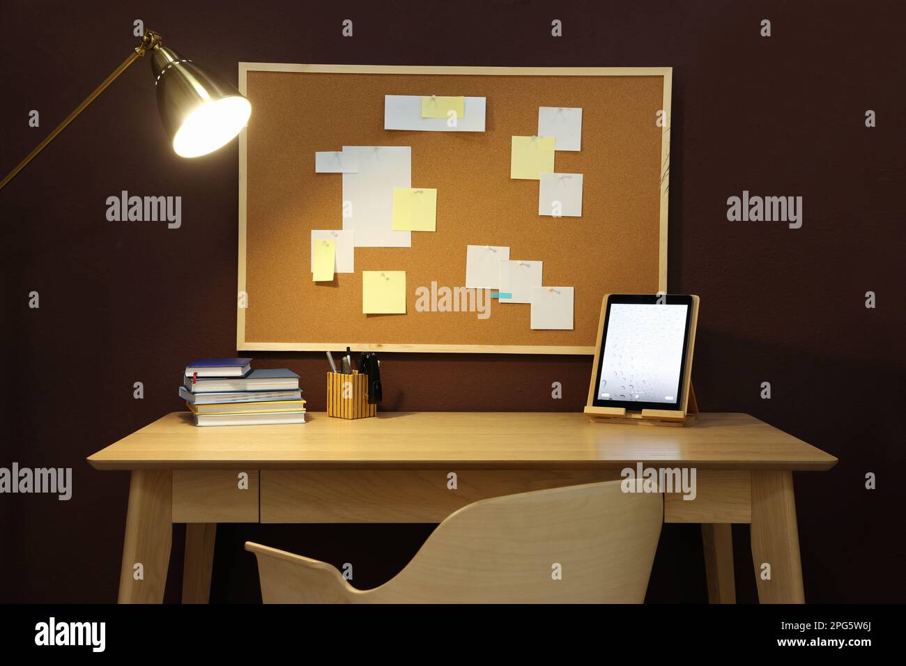 Stylish workplace with wooden table and cork board Stock Photo - Alamy
