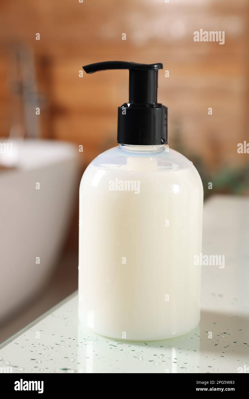 Dispenser of liquid soap on white table in bathroom Stock Photo - Alamy
