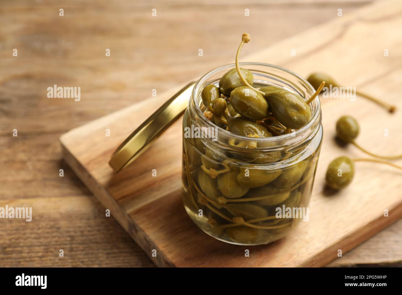 Jar of capers on wooden table, closeup. Space for text Stock Photo - Alamy