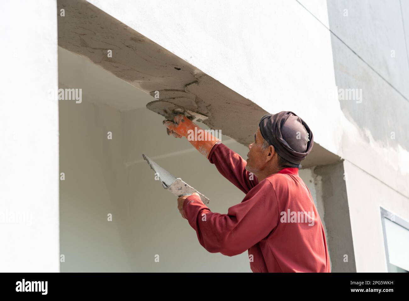 Worker plastering cement at wall for building house Stock Photo - Alamy