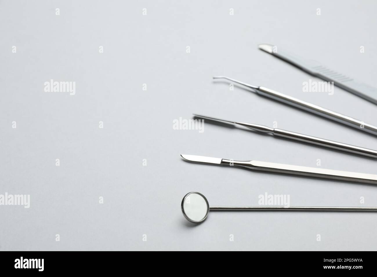 Set of different dentist's tools on light grey background. Space for ...