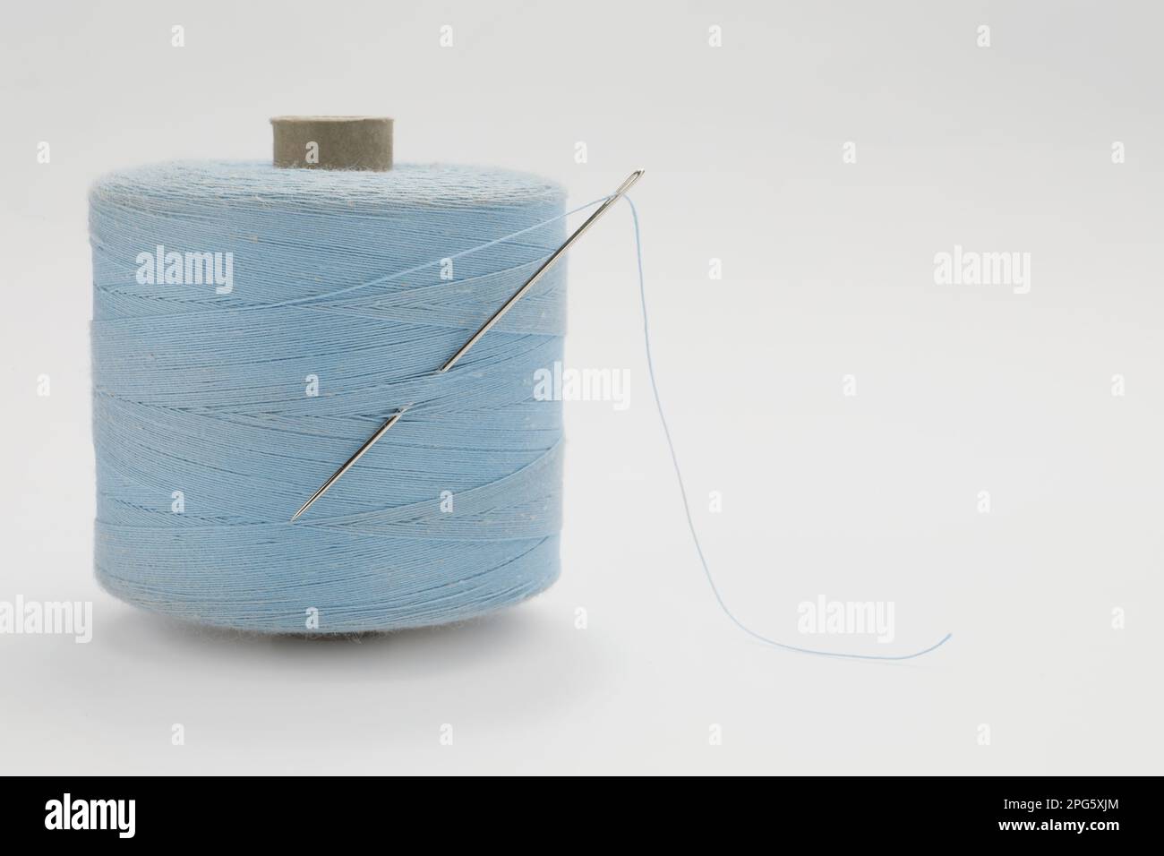 Light blue sewing thread with needle on white background Stock Photo ...