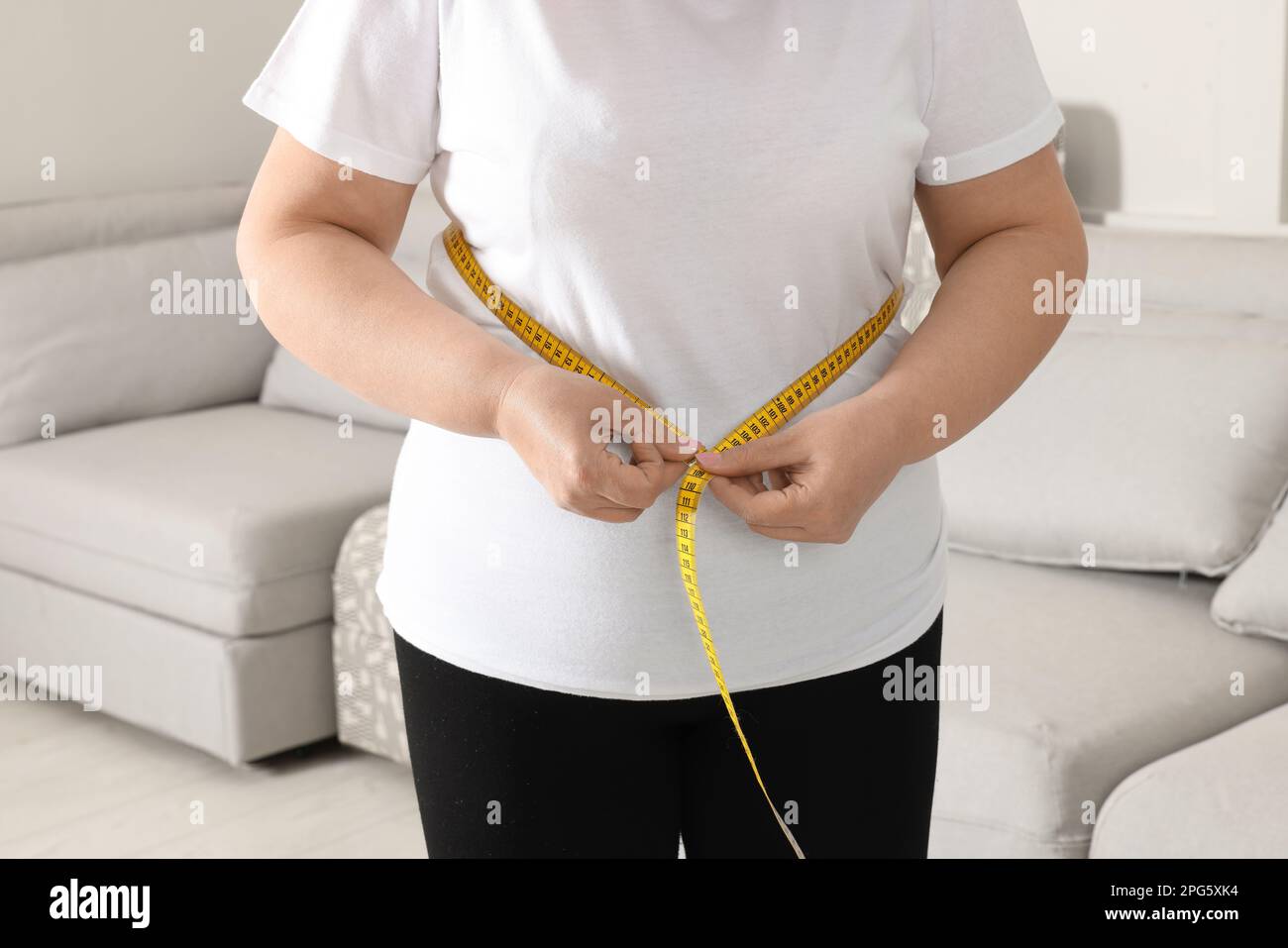 Overweight woman measuring waist hi-res stock photography and images ...