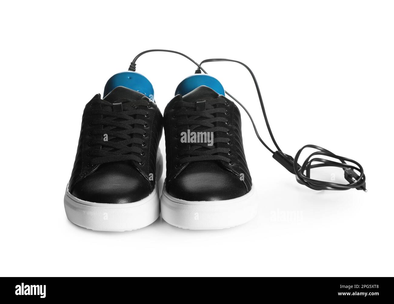 Pair of stylish shoes with modern electric footwear dryer on white ...