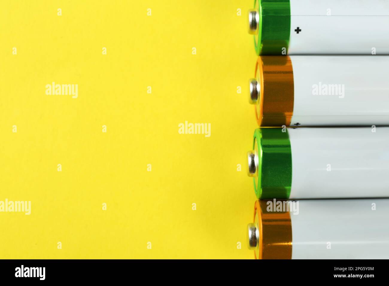 New AA batteries on yellow background, flat lay. Space for text Stock ...